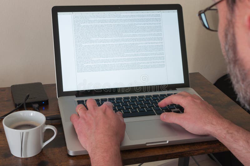 Man Working on Laptop and Writing in a Notebook Stock Photo - Image of ...