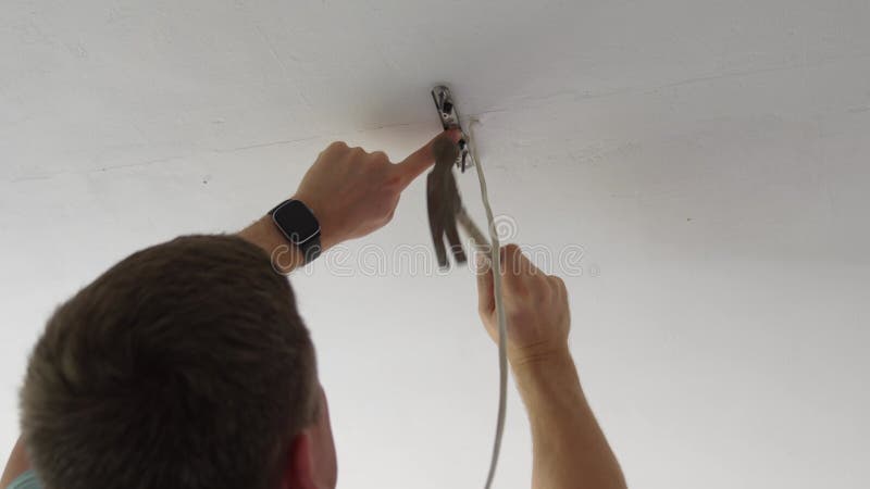 A Man is Working on the Installation of a Ceiling Luminaire on the ...