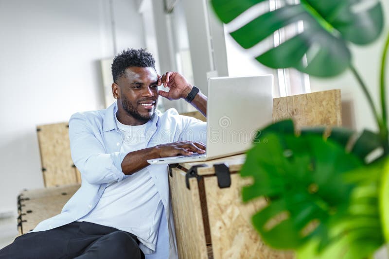 A Man Working on a Laptop in a Bright Modern Workspace Surrounded by ...