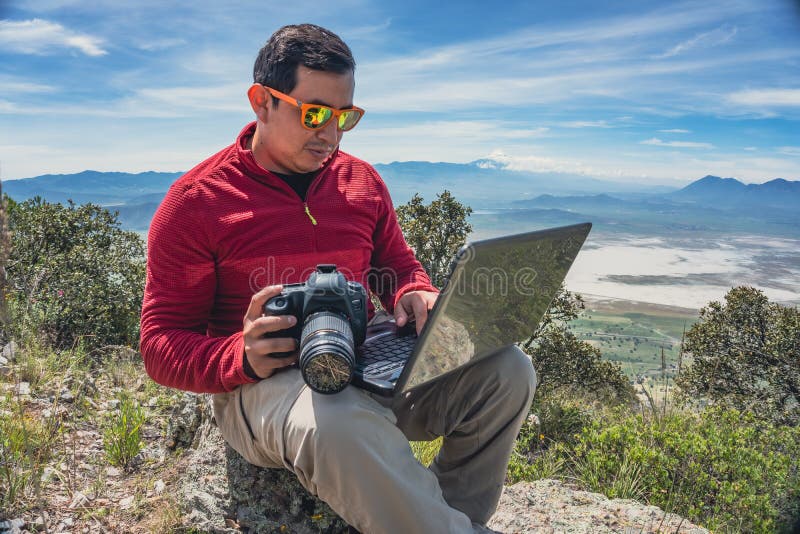 Man Working with Laptop and Camera on the Top of Mountain Stock Image ...