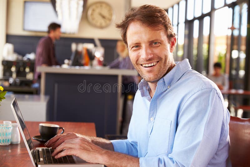 Man Working on Laptop in a Coffee Shop Stock Image - Image of middle ...