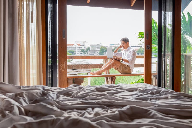 Man Working on Laptop Computer at Hotel Balcony by the River. Stock ...