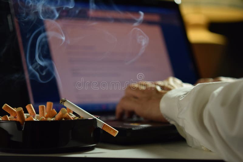 Man Working on Laptop Computer with Lit and Smoking Cigarette Stock ...