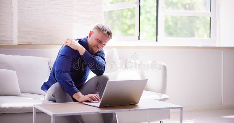 Man Working on Laptop Computer with Shoulder Injury Pain Stock Photo ...