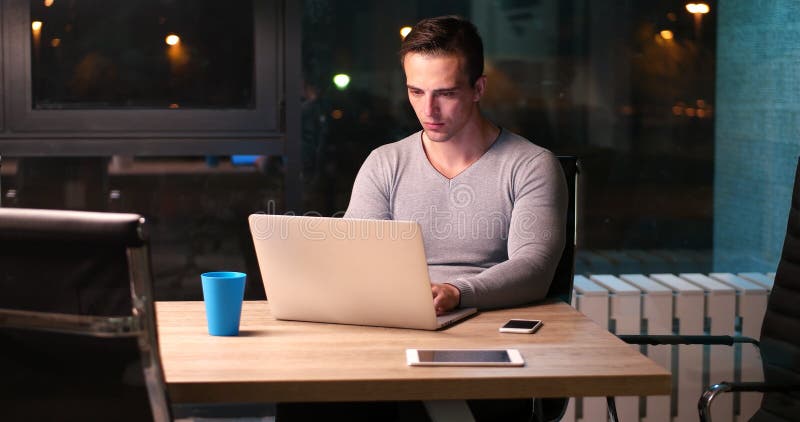Man Working on Laptop in Dark Office Stock Photo - Image of busy ...