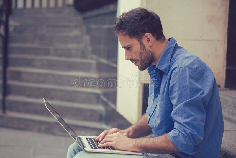 Man Working on Laptop Outdoors Sitting on Steps Outside of His Office ...