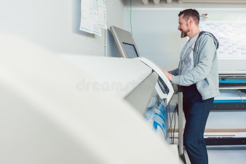 Man Working on Large Format Printer in Advertising Agency Stock Photo ...