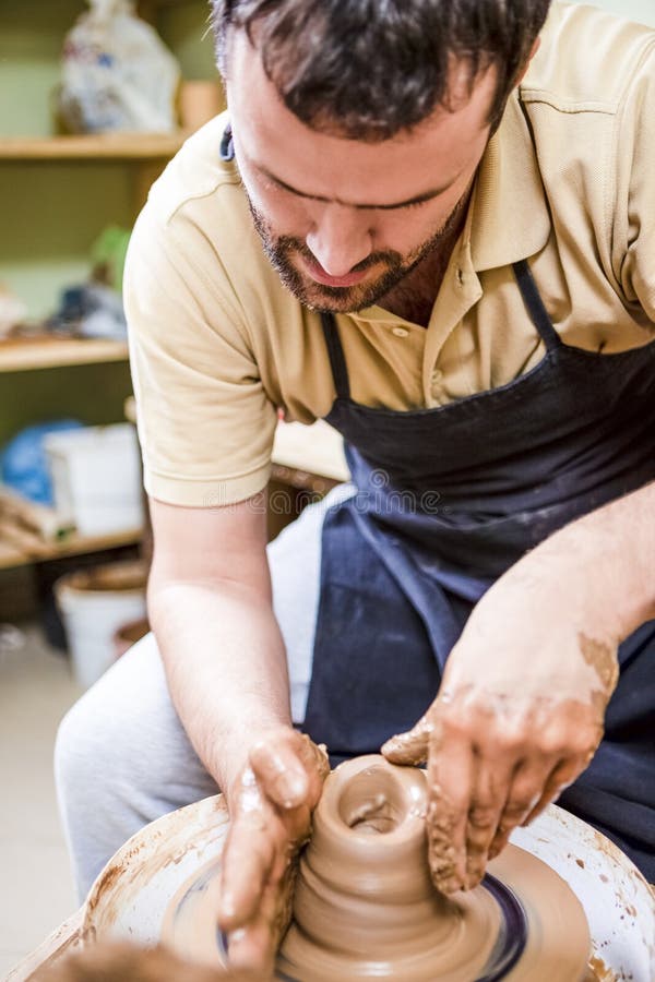 Man Working with Lump of Clay on Potter`s Wheel in Workshop. Pre Stock ...