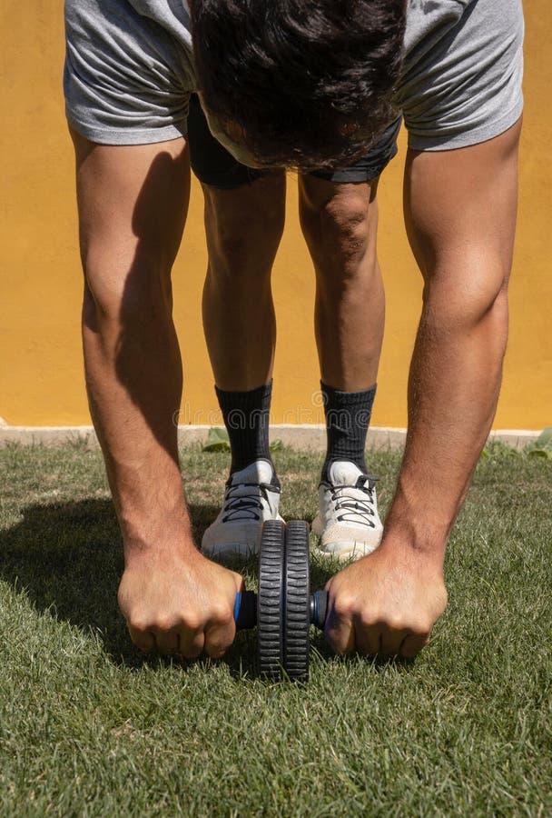 Man Working Out with Double Wheel Ab Rollers Outdoors Below Harsh ...
