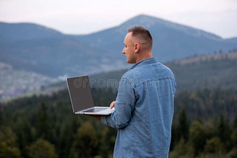 Man Working Outdoors with Laptop in Mountains. Concept of Remote Work ...