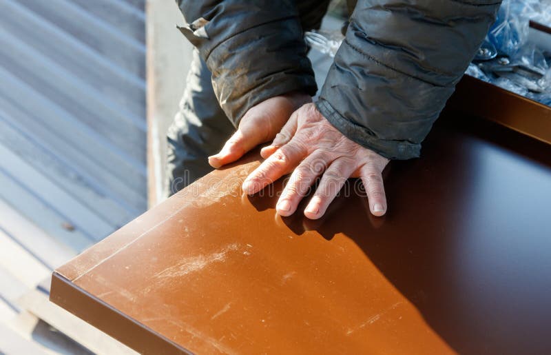 A Man is Working on a Piece of Wood, Sanding it Down Stock Photo ...