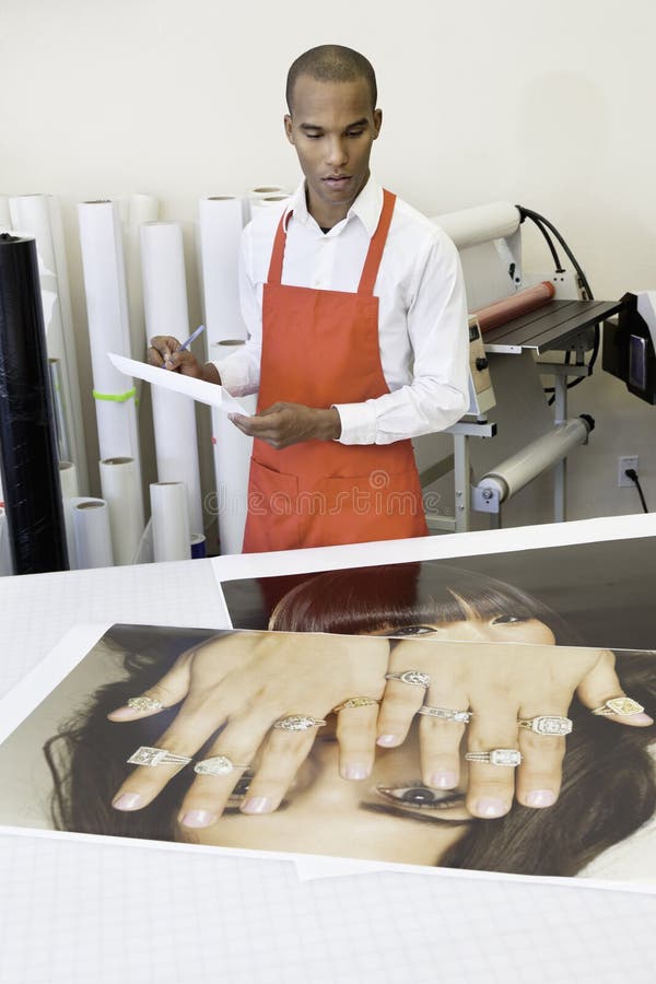 Man Working at Printing Press with Photo Printouts on Table Stock Image ...
