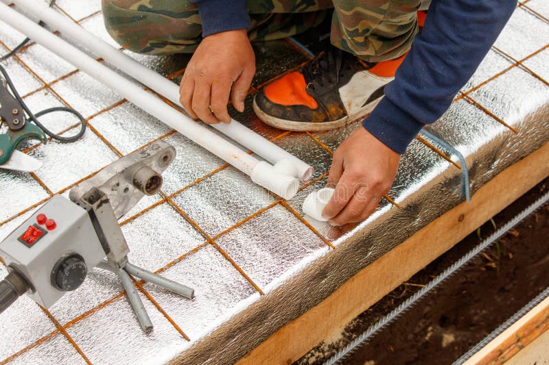 A Man is Working on a Project, Using a Tool To Cut a Piece of Pipe ...