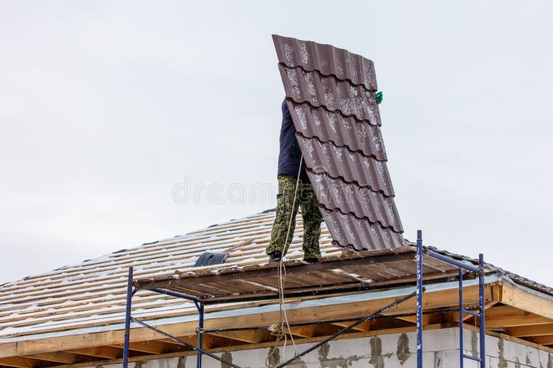A Man is Working on a Roof, and the Roof is Covered in Snow Stock Image ...