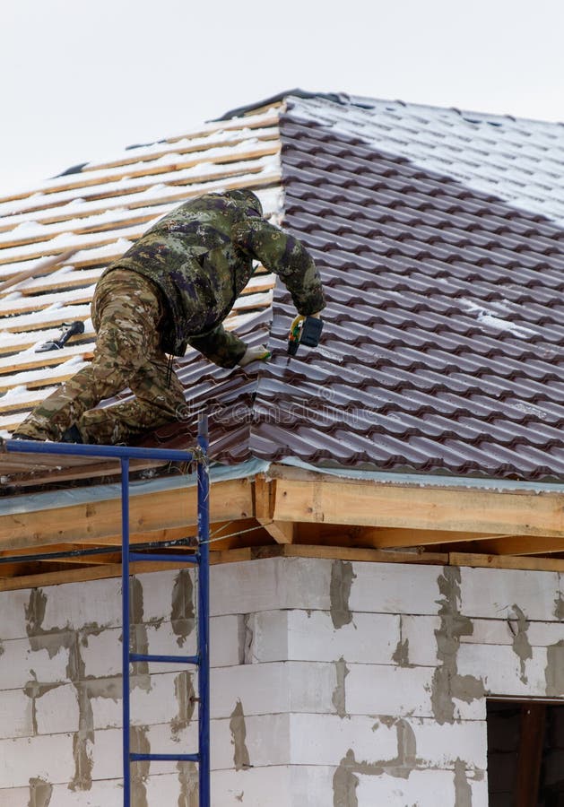 A Man is Working on a Roof, and the Roof is Made of Tiles Stock Photo ...