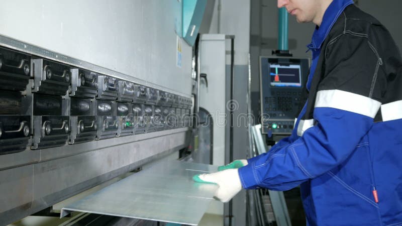 Man Working with Sheet Metal on CNC Hydraulic Press Brake. he Puts the ...