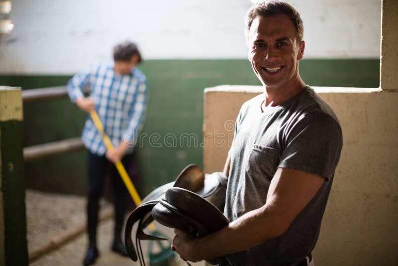 Man working in the stable stock photo. Image of ranch - 97393992