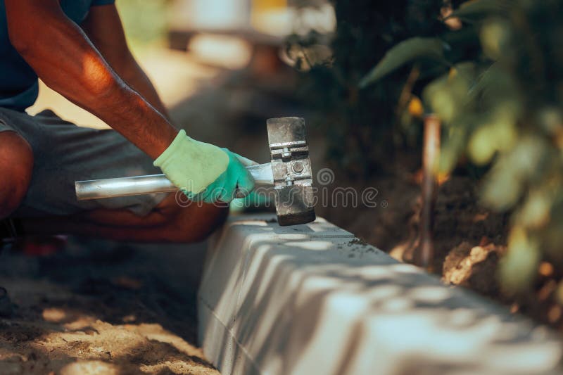 Construction Worker Using a Hammer for Fixing New Curb Blocks Stock ...