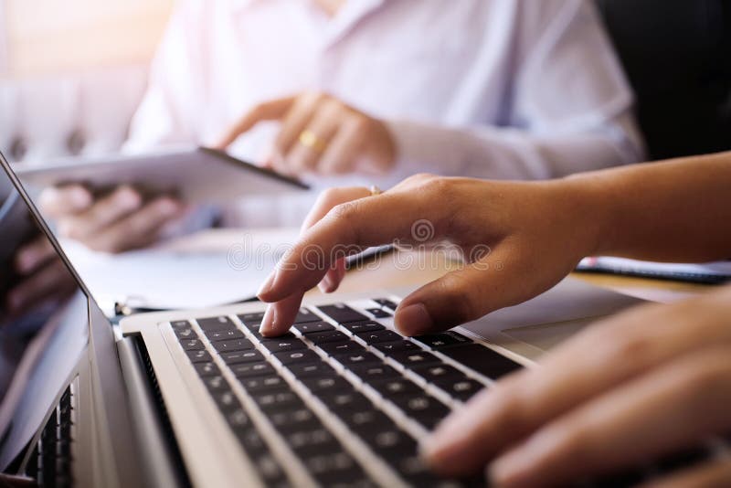 Man Working by Using a Laptop Computer on Wooden Table. Hands Ty Stock ...
