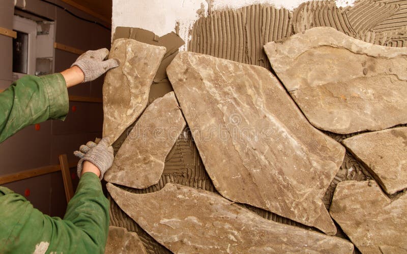 A Man is Working on a Wall with a Trowel, Laying Down a Layer of Cement ...