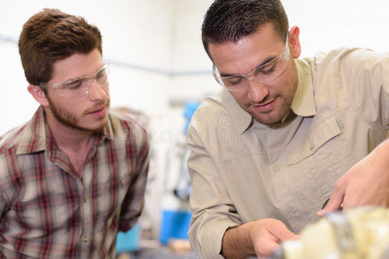 Man Working in Workshop Apprentice Watching Both Wearing Goggles Stock ...