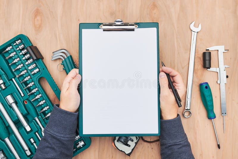 Man Working in Workshop Holding Clipboard Using Many Tools. Wrench ...