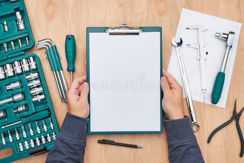 Man Working in Workshop Holding Clipboard Using Many Tools. Wrench ...