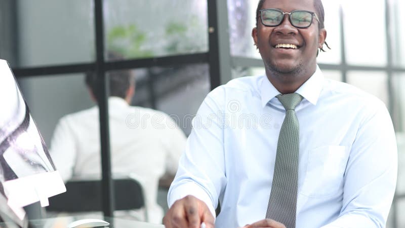 A Man at a Workplace at a Table in Front of a Computer Writes Down ...
