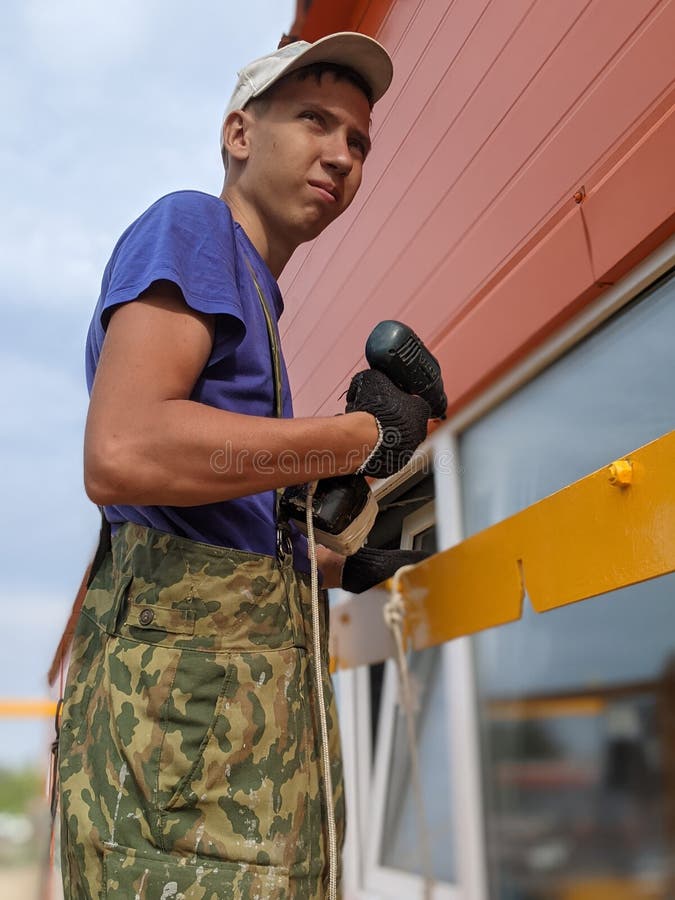 The Man Works, Builds the Facade of the Building. Stock Image - Image ...