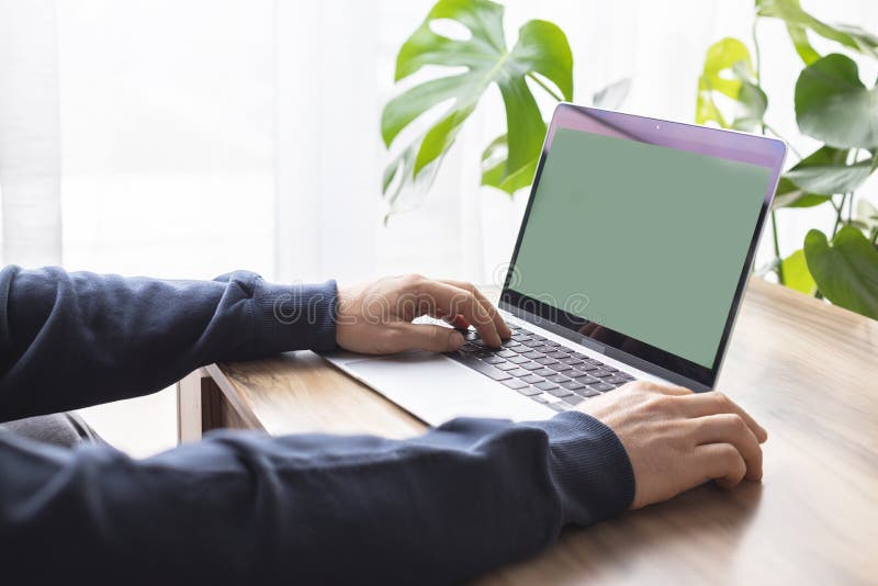 A Man Works at a Computer at Home, in an Office or in a Cafe. Remote ...