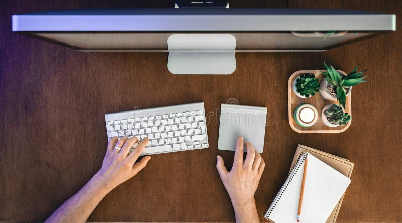 A Man Works at a Computer, Top View. Desktop Computer on a Wooden Table ...