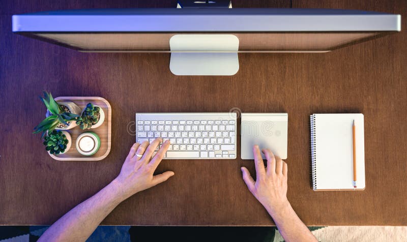 A Man Works at a Computer, Top View. Desktop Computer on a Wooden Table ...