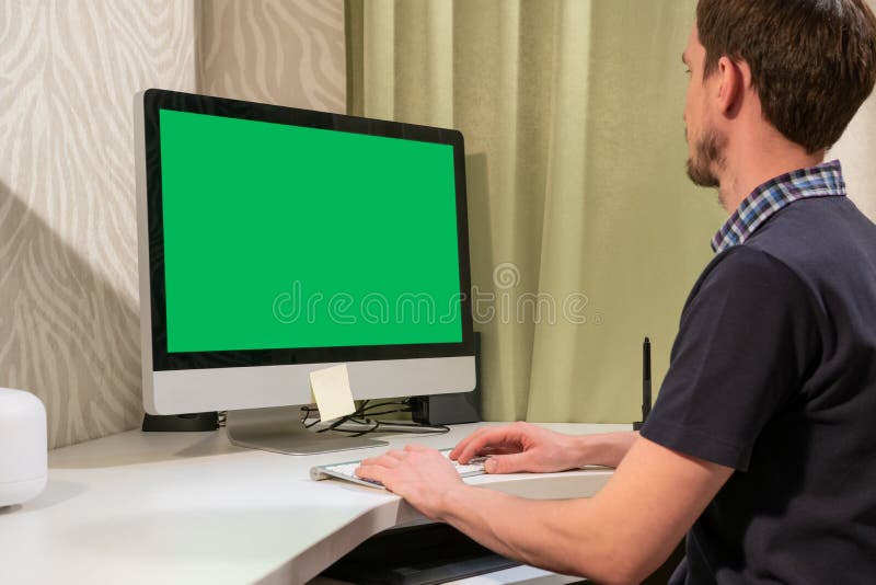 A Man Works in Front of a Computer with a Green Screen Stock Photo ...
