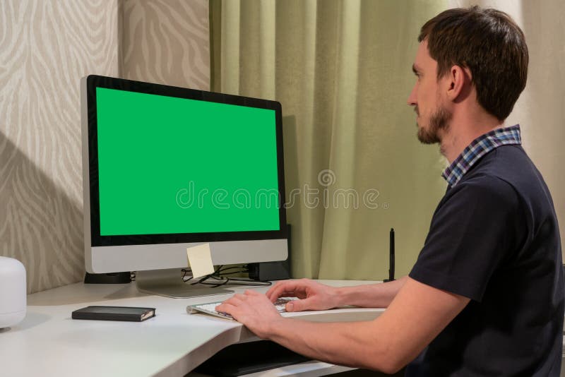 A Man Works in Front of a Computer with a Green Screen Stock Image ...