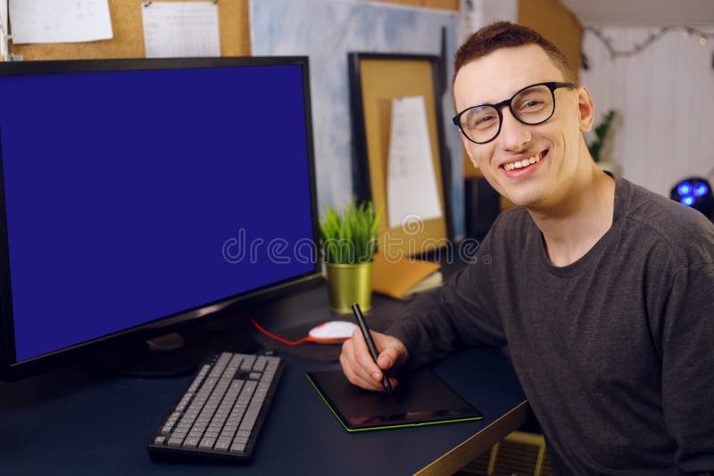 A Man Works at Home with a Tablet and Pen. Griffin Designer, a Man ...