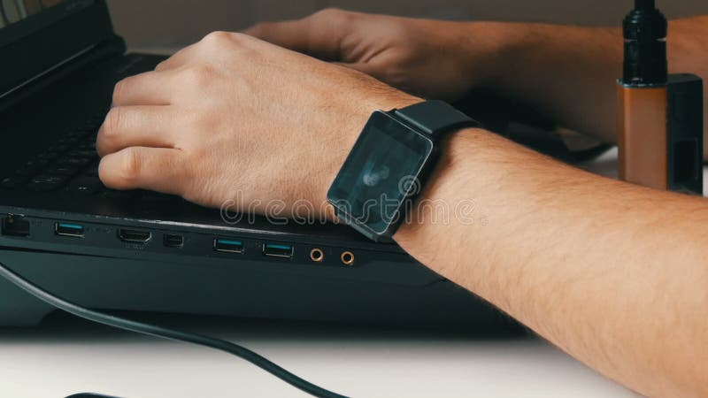 A Man Works at Laptop. Men`s Hands with a Smart Watch and an Electronic ...
