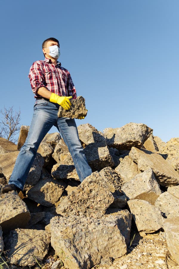 A Man Works with a Pile of Stones and Broken Pieces of Concrete ...