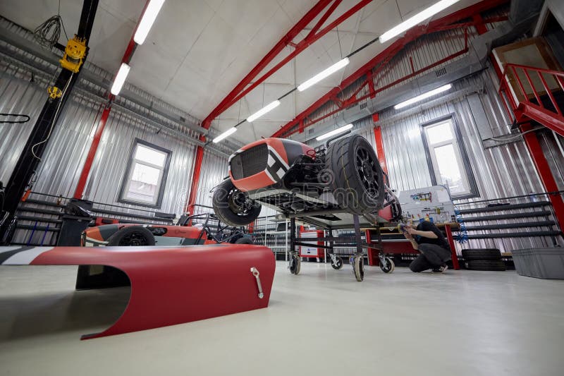 Man Works with Racing Car on Wheeled Rack Stock Photo - Image of rack ...