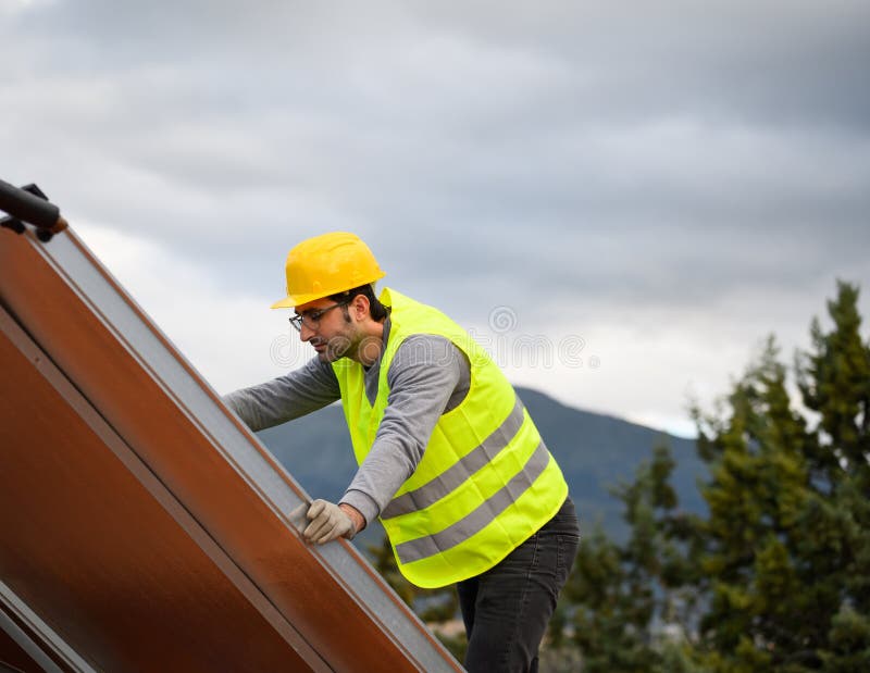 Man Works on Renewable Energy System with Solar Panel for Hot Water ...
