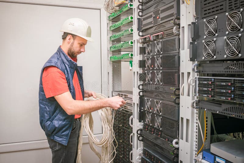 A Technician Connects Fiber Optic Wires To a Central Router. a Man ...