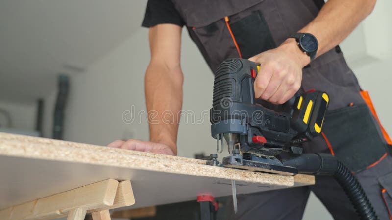 Man Cutting Chipboard with Electric Jigsaw in Home Garage Workshop ...