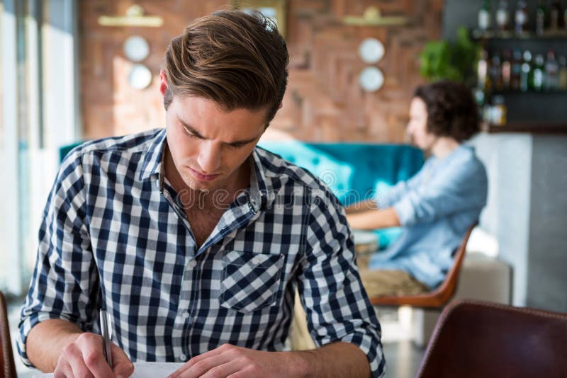 Man writing in coffee shop stock photo. Image of shop - 76024810