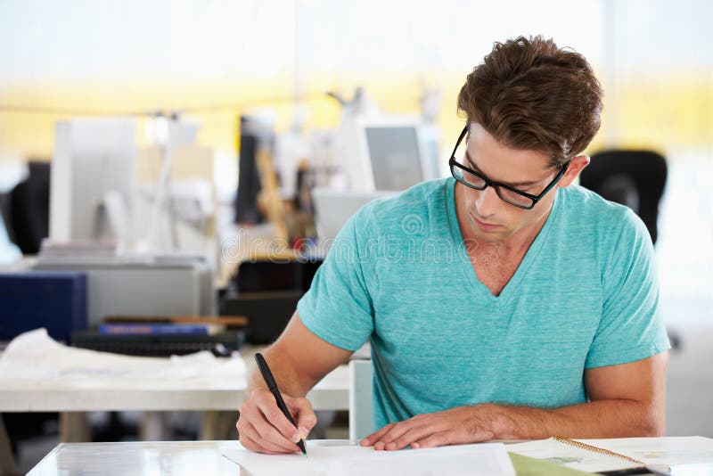 Man Writing at Desk in Busy Creative Office Stock Photo - Image of ...