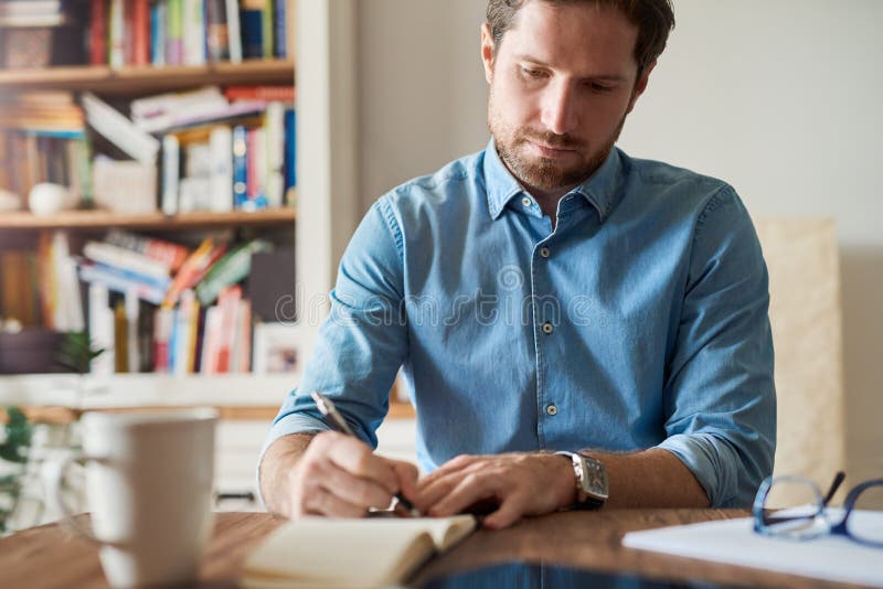 Man Writing Down Notes while Working in His Living Room Stock Photo ...