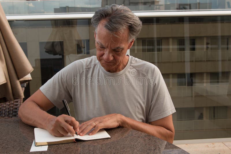 Man writing in his Journal stock image. Image of holding - 167087377