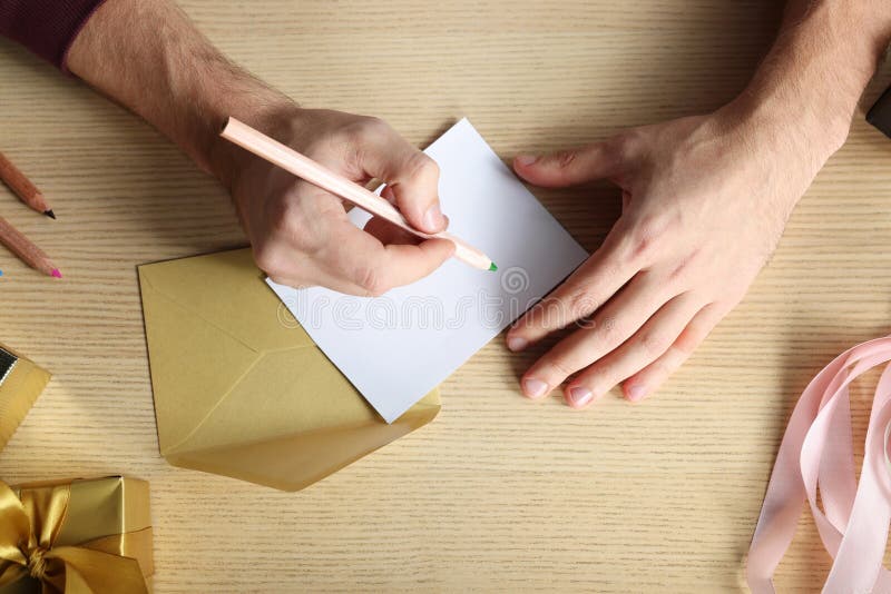 Man Writing Message in Greeting Card at Wooden Table, Top View Stock ...