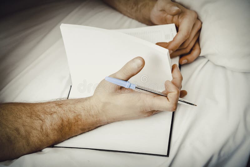 Man writing a note in bed. stock photo. Image of home - 92889284