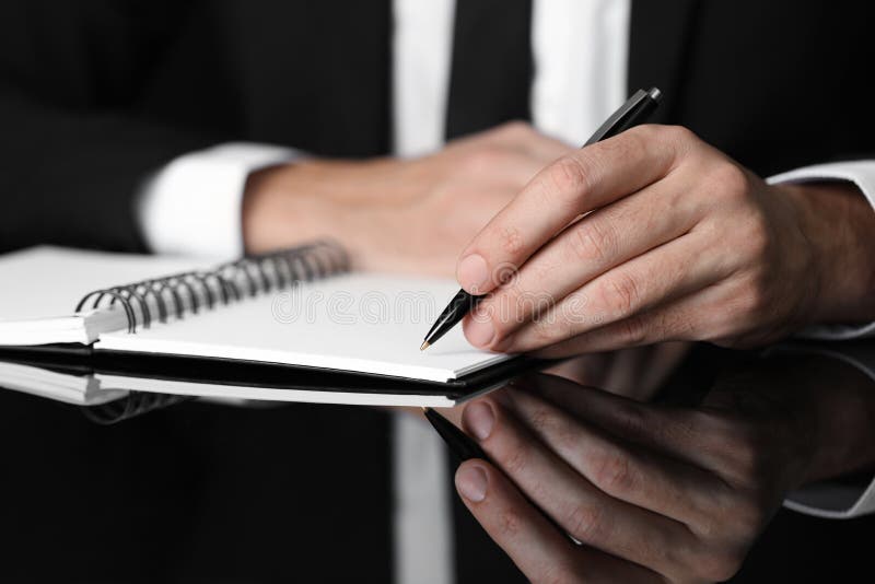 Man Writing in Notebook at Black Table, Closeup Stock Photo - Image of ...