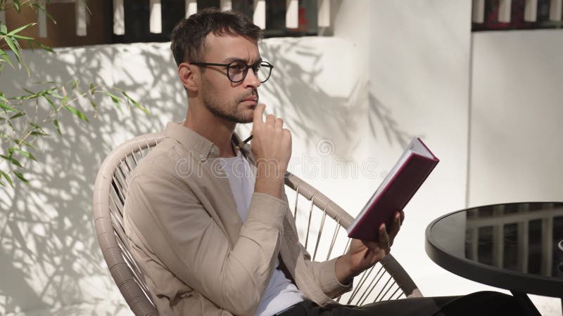 Man Writing in Notebook at Outdoor Cafe Stock Footage - Video of chair ...