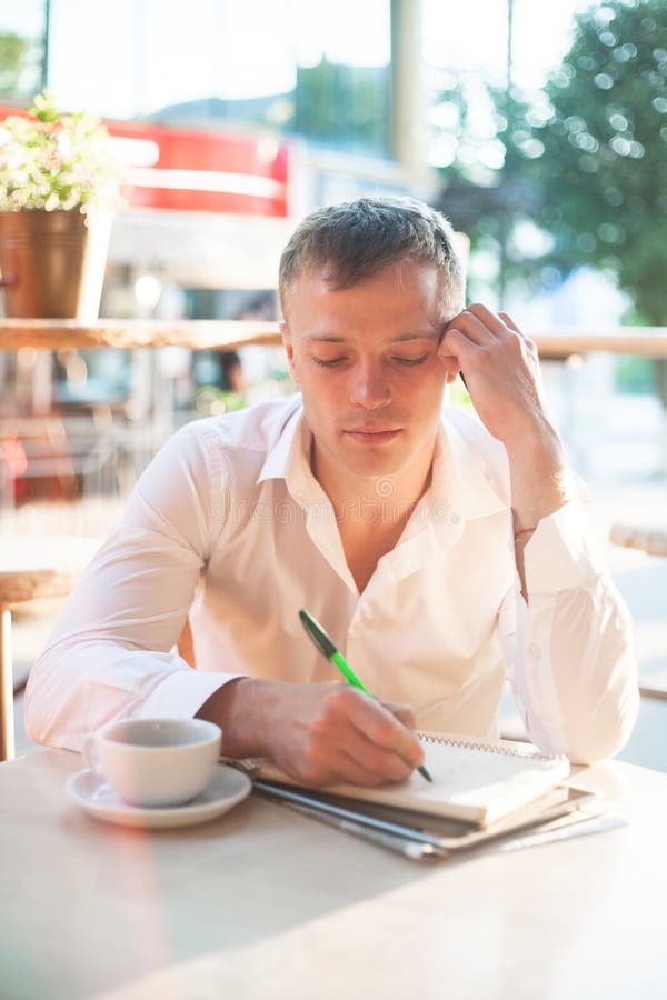 Man Writing on Notebook or Planner with Smartphone and Coffee at ...